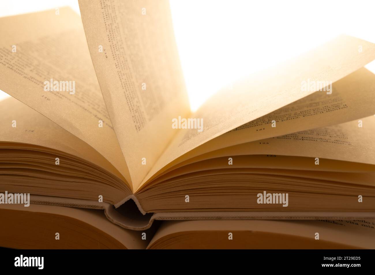 Open book and pages turned, backlit, on a white background. Passion for ...