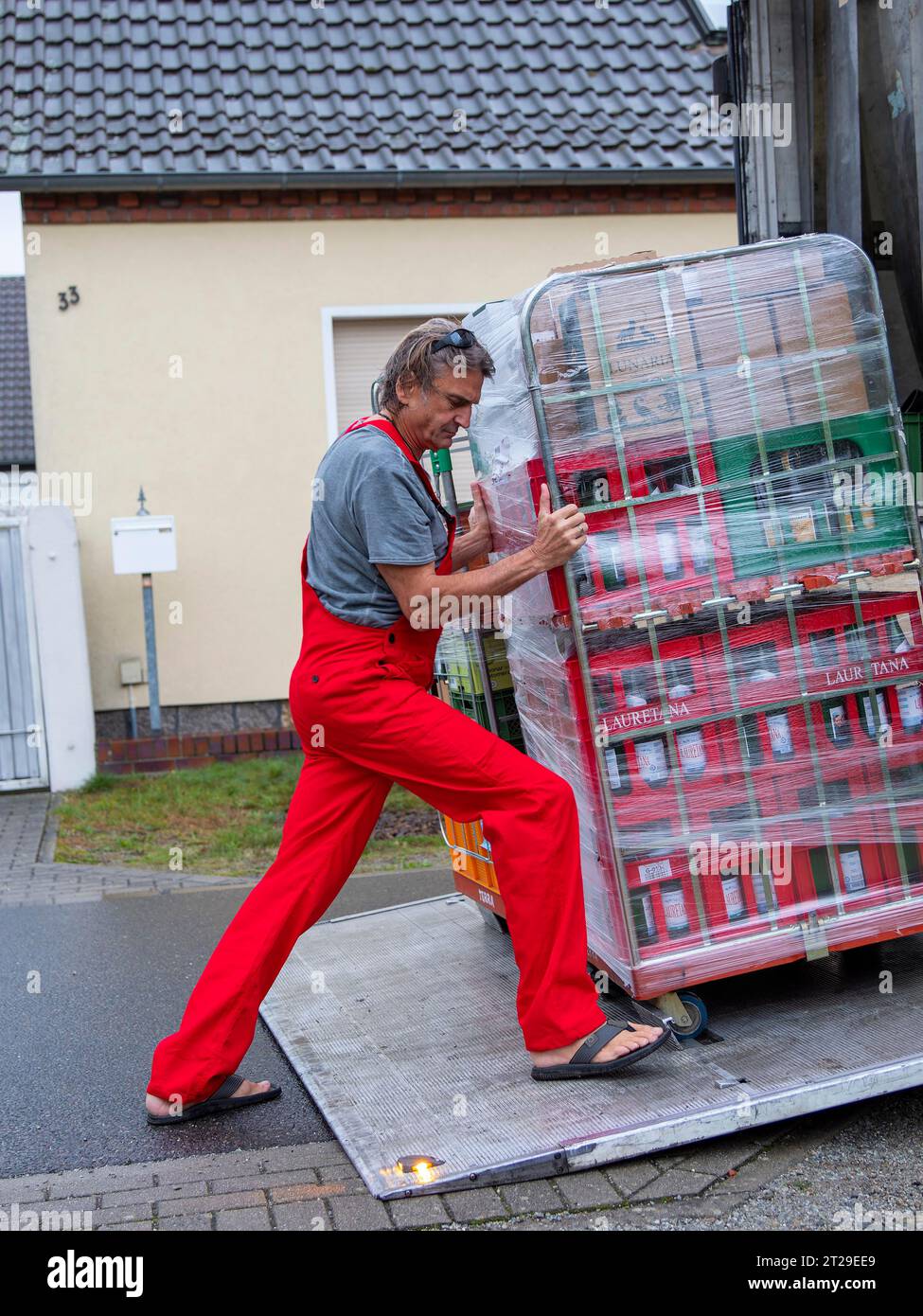 Man at loading ramp truck, delivery with organic goods and water boxes ...