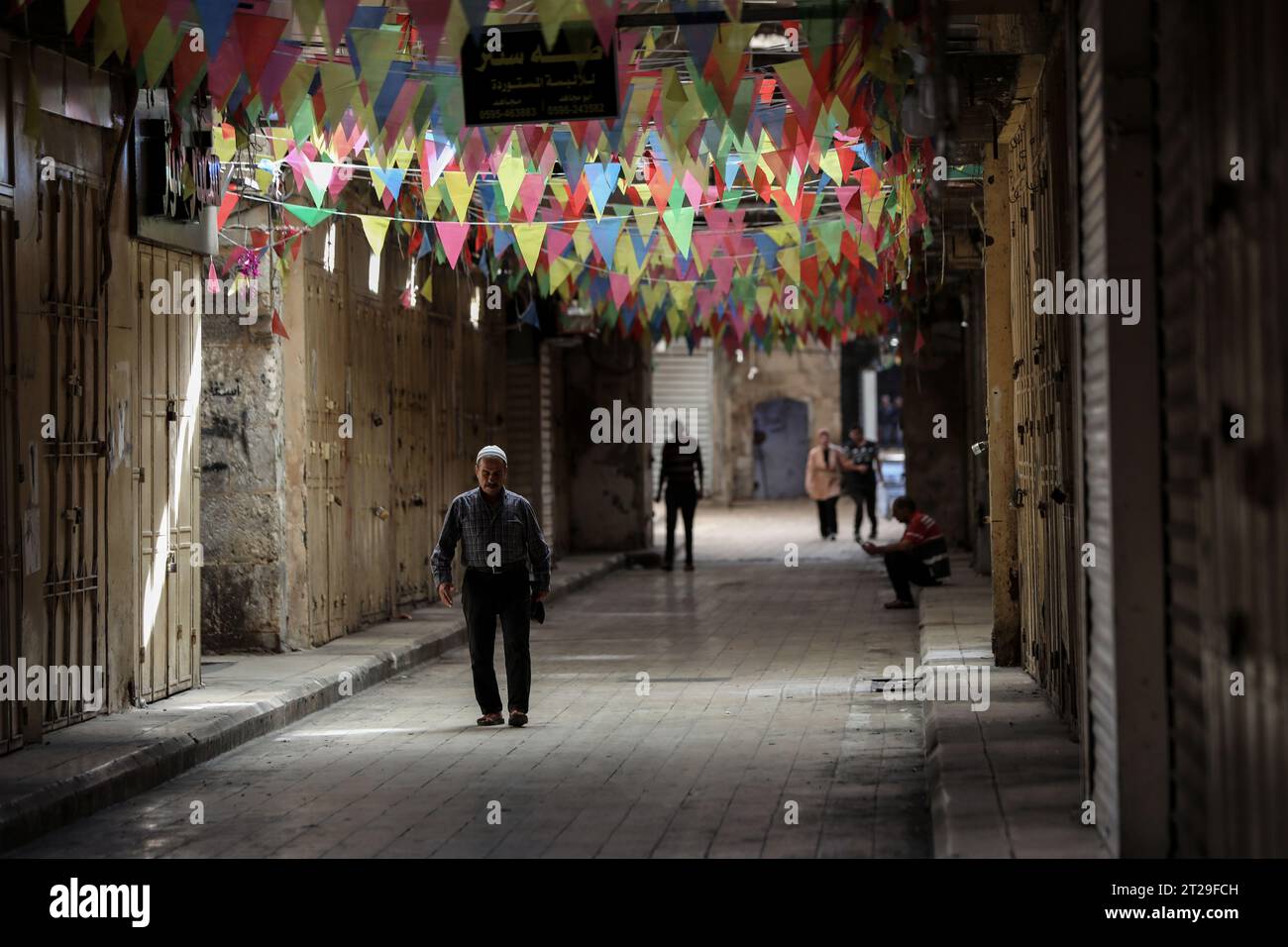 Nablus, Palestinian Territories. 18th Oct, 2023. People walk past ...