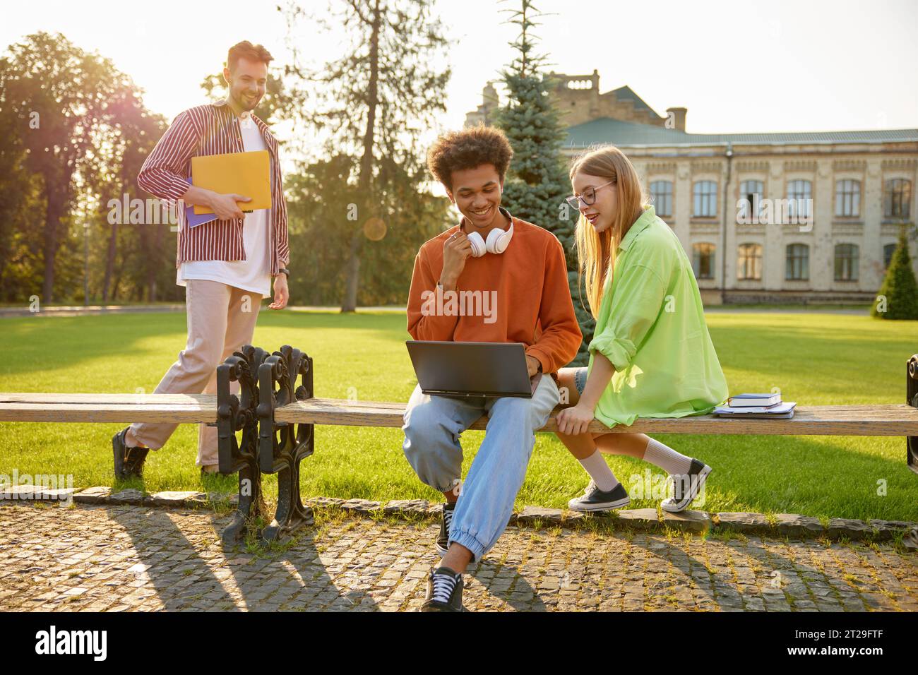 Smiling students using laptop together hi-res stock photography and ...