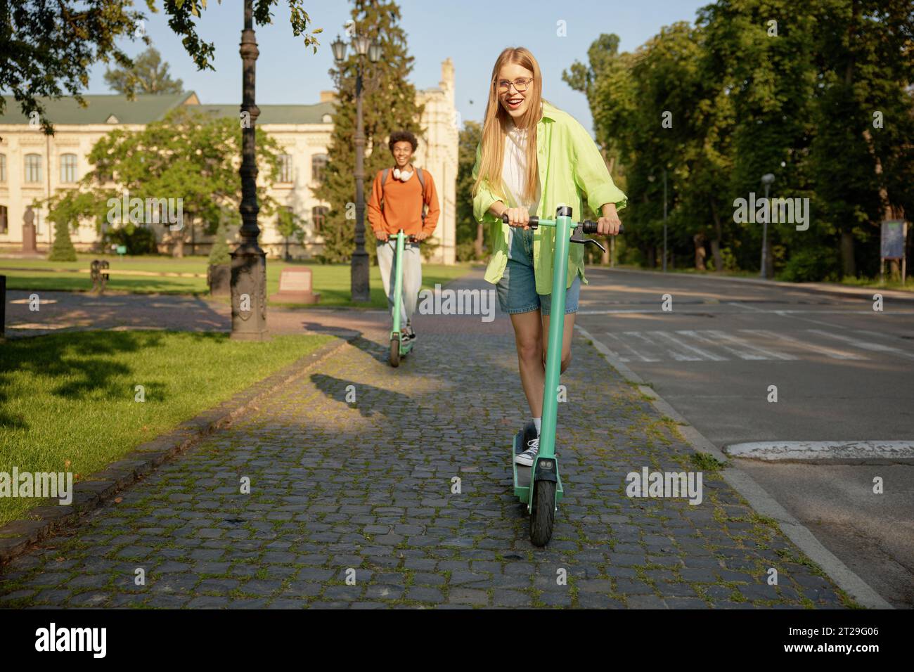 Interracial company of students using electric scooter vehicles Stock ...