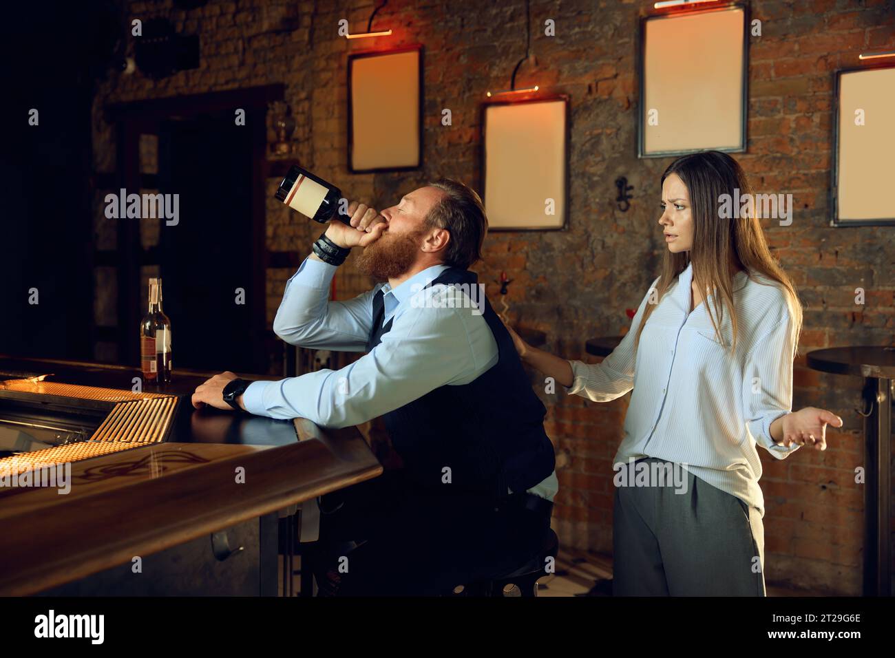Irritated wife scolding drunk husband while he abusing alcohol at pub ...