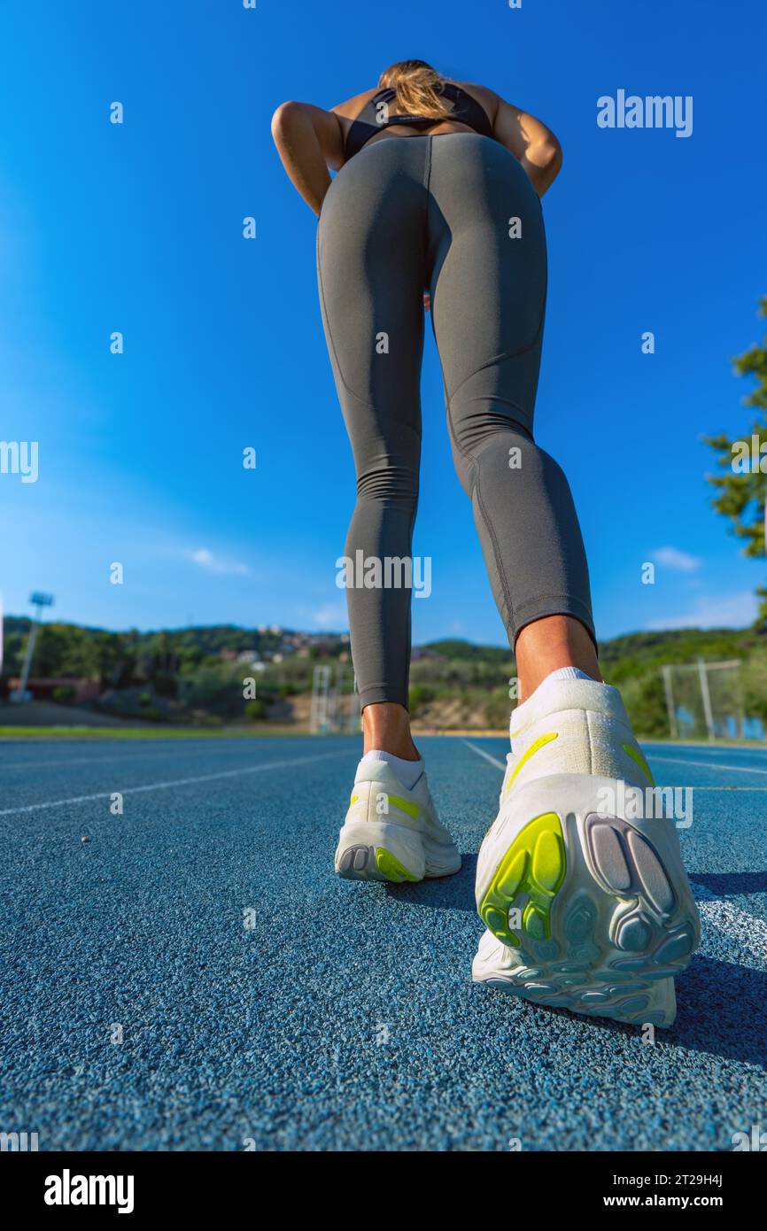 Low angle shot of tanned young girl dressed in sports tights running on ...