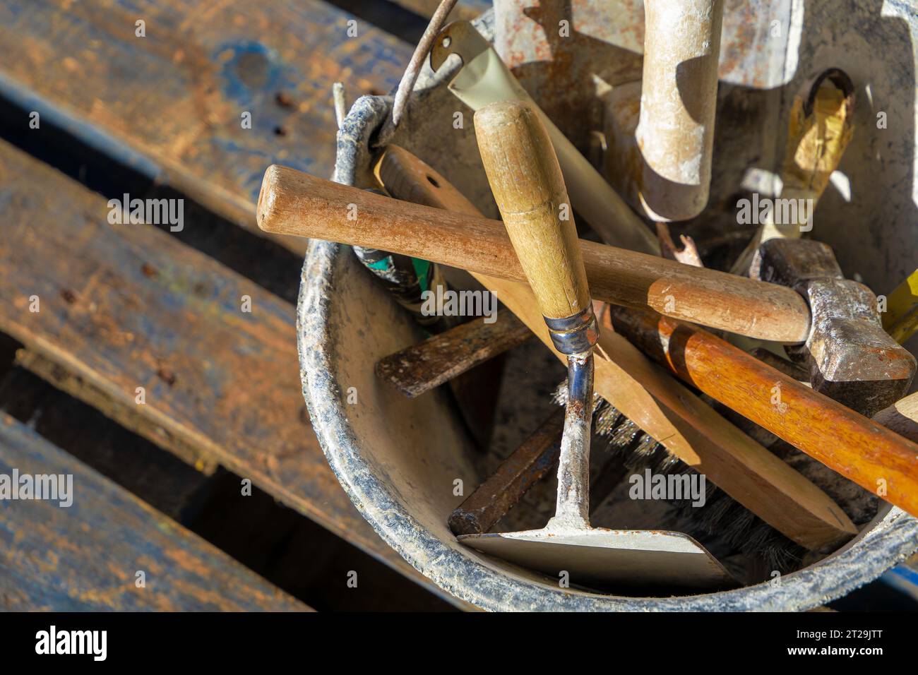 Used construction tools, stored in a bucket, outdoors. View from above ...