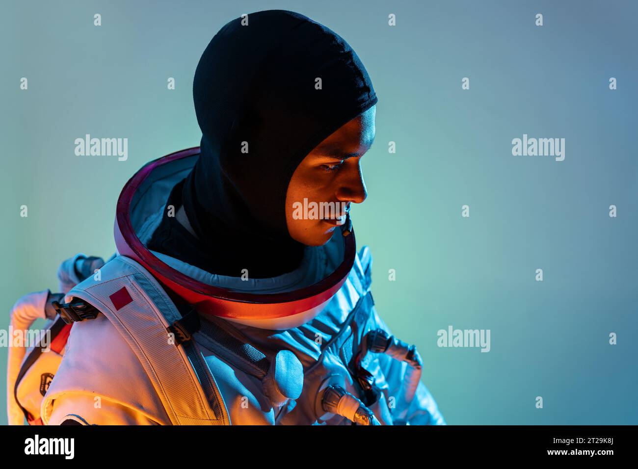 High angle of male astronaut in spacesuit and head cover hood looking ...
