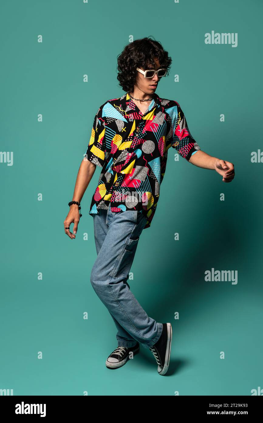 Excited young Latin American funky dancer in sunglasses dancing moving ...