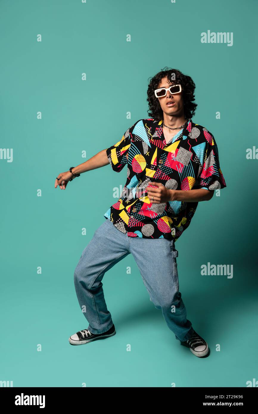 Excited young Latin American funky dancer in sunglasses dancing moving ...
