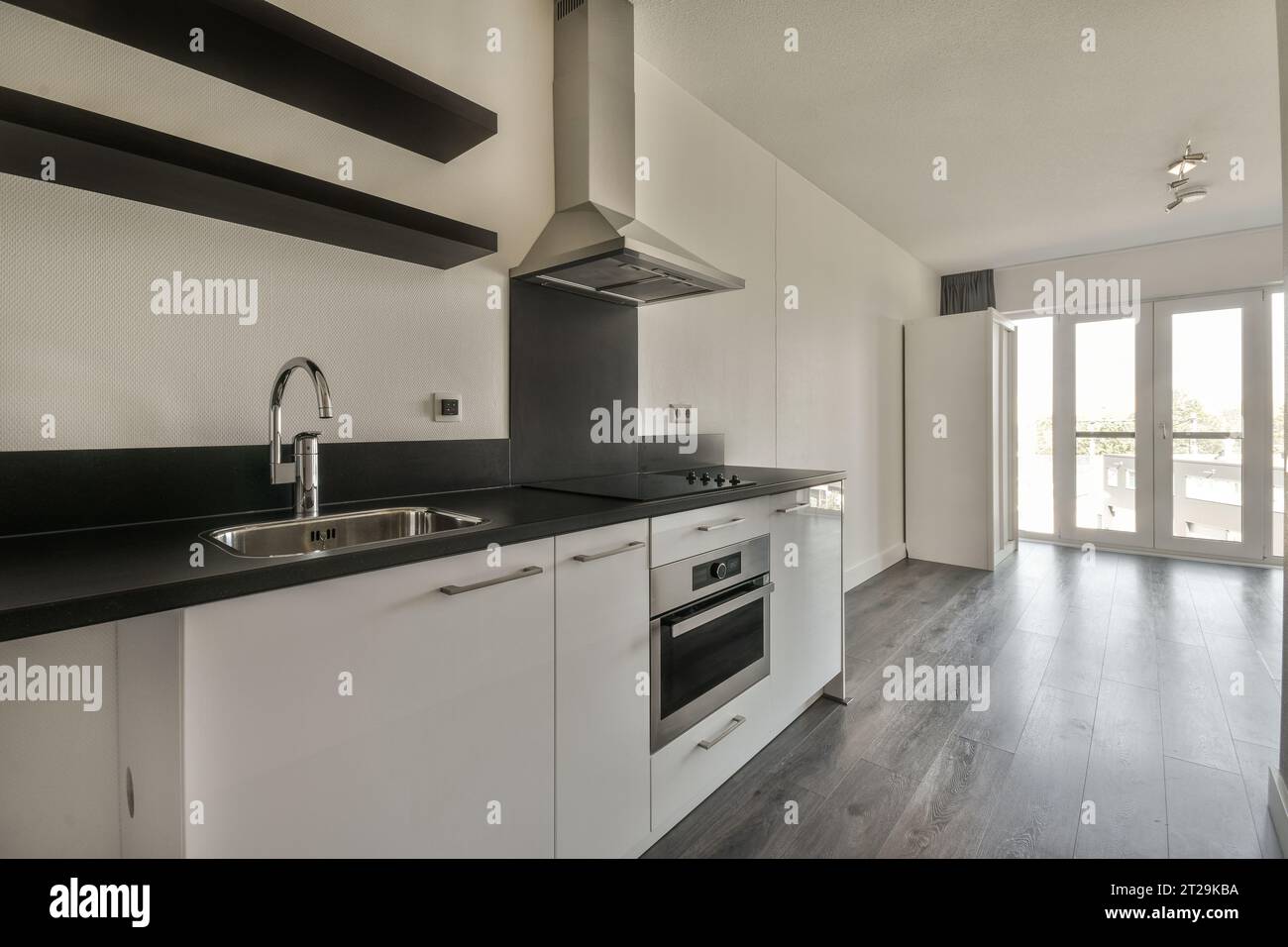 Interior of empty white kitchen with windows and wooden parquet floor ...