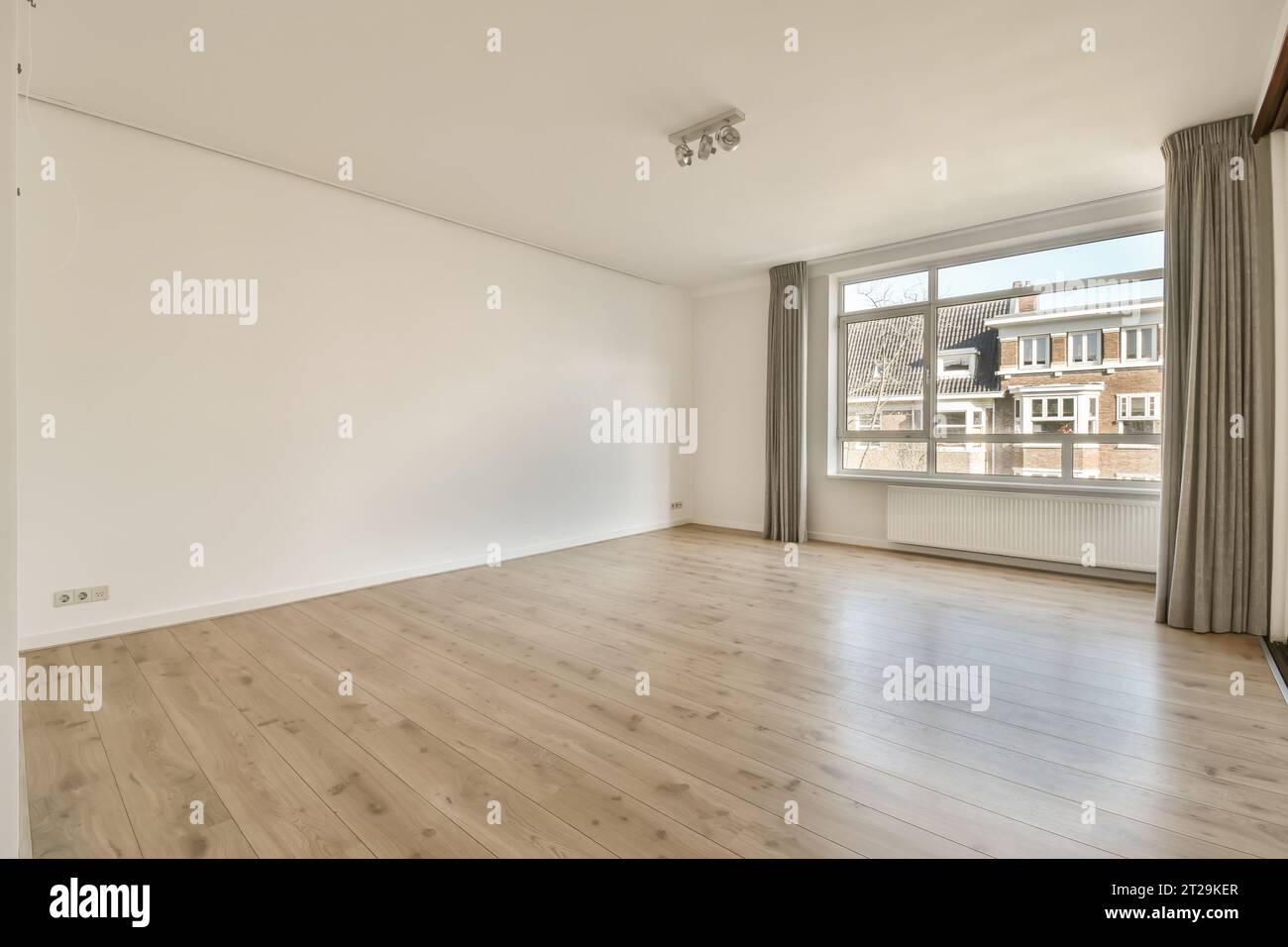 Interior of empty spacious living room with large window and white ...