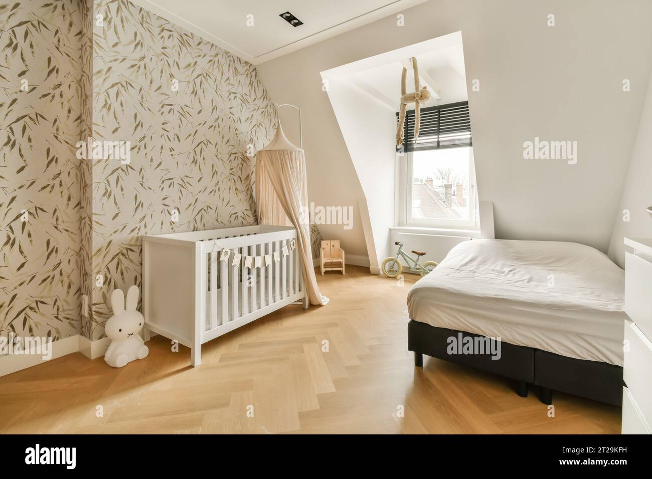 Interior of baby's room with crib and comfortable bed placed by window ...