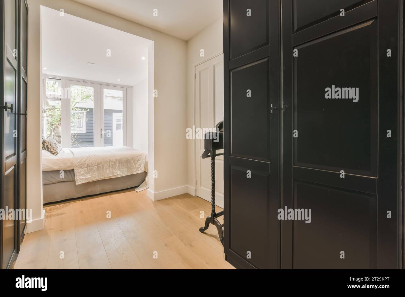 Interior of spacious bedroom with large black wardrobes and comfortable ...