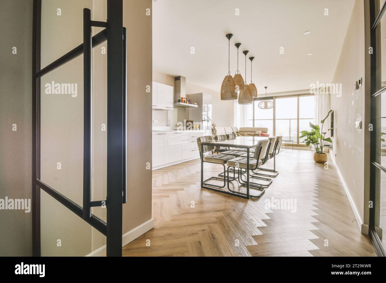 Pendant lights hanging over dining table and chairs arranged in ...