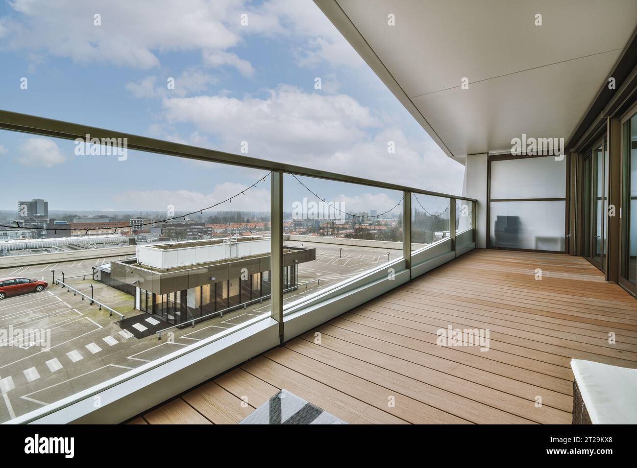 Empty wooden balcony of modern apartment with glass railing overlooking ...