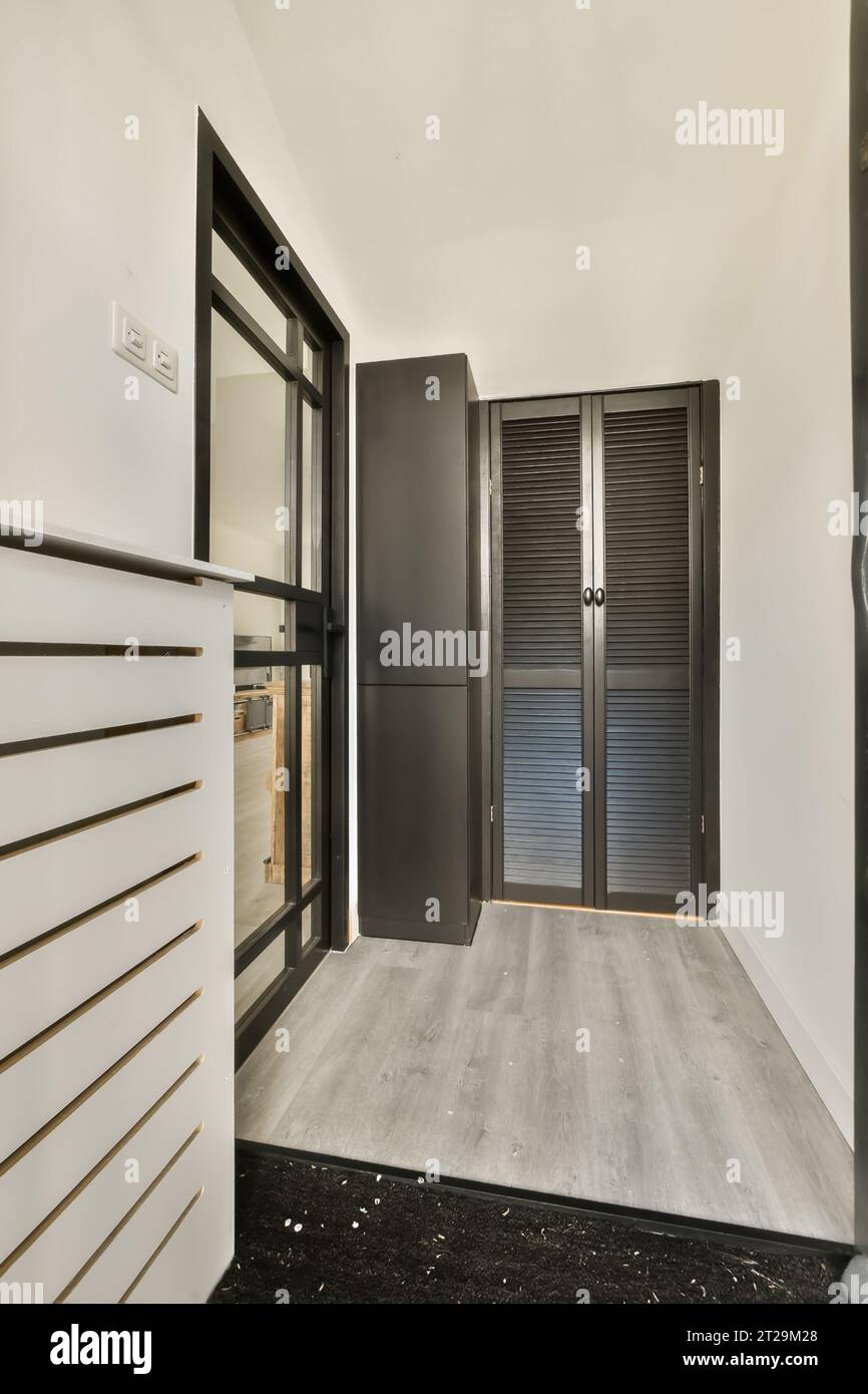 Interior of empty hallway with closed black doors and white wall in ...