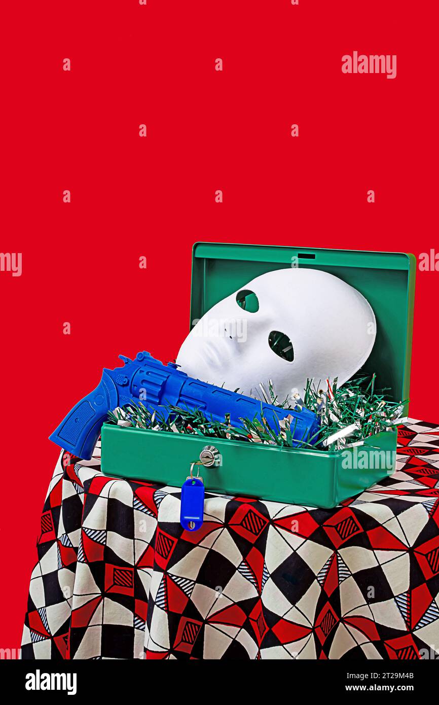 Opened secret box with mask, toy gun and tinsel placed on table against ...