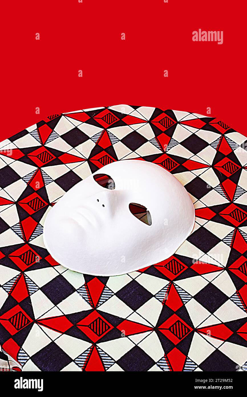 High angle of white mask placed on table against red background Stock ...