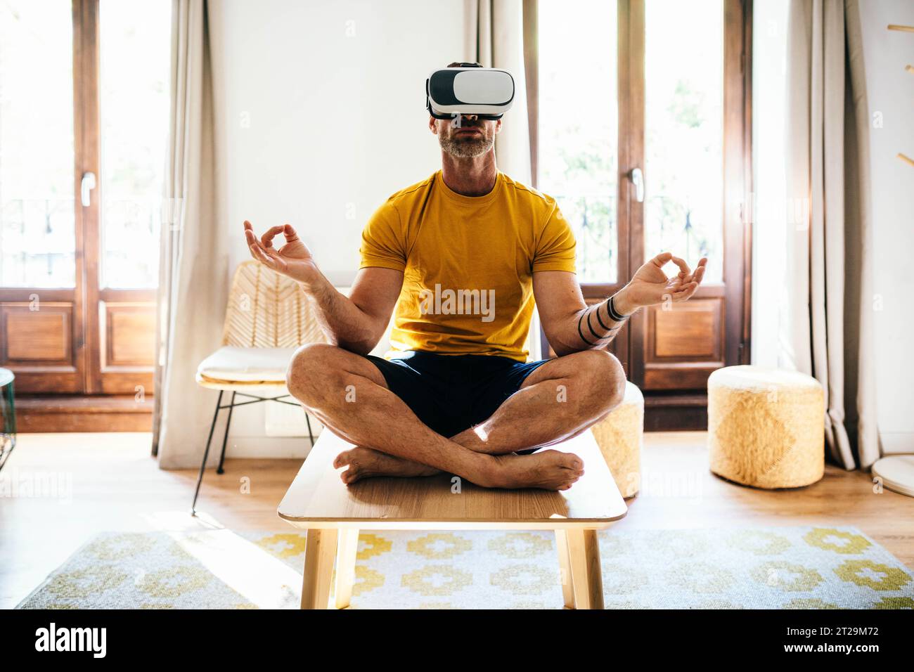 Full body of anonymous male in VR goggles while sitting in room on ...