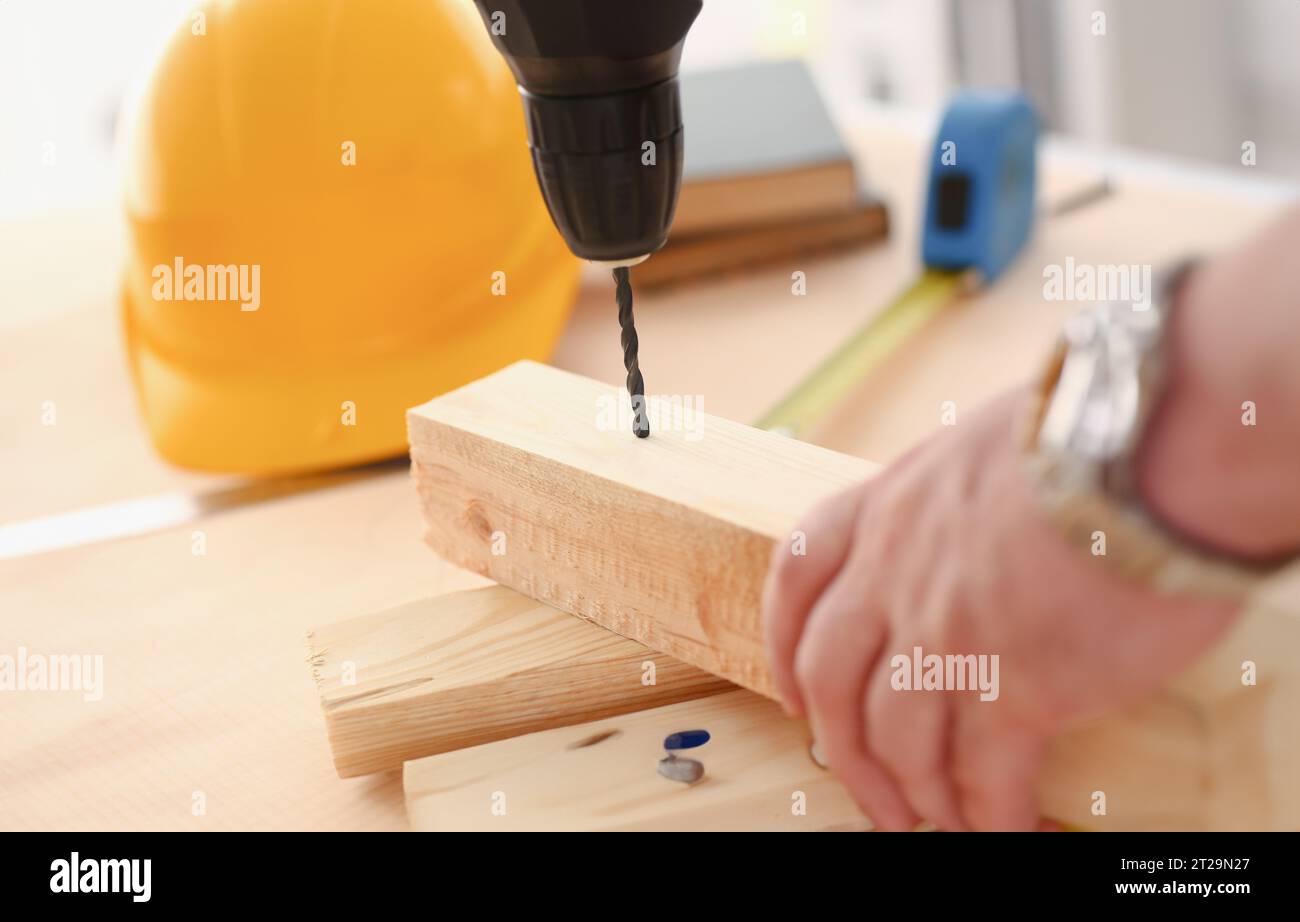 Arms of worker using electric drill Stock Photo - Alamy
