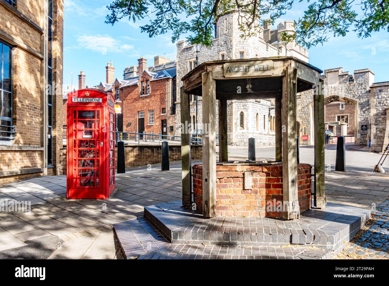 An old ancient well and red telephone box stand outside Windsor Castle ...
