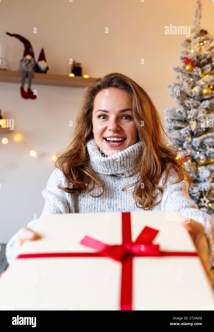 Season of giving. Young happy woman receiving a Christmas present box ...