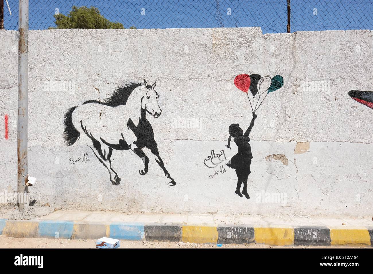 Dhiban Jordan street art in the style of Banksy on a wall in the small ...