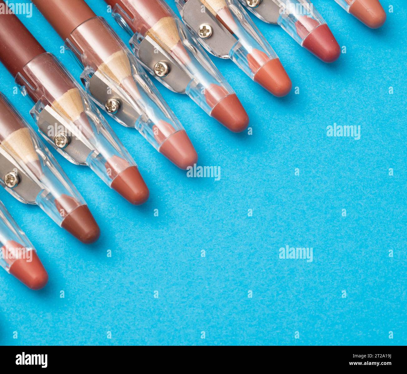 Set of brown soft lip pencils on a blue background. Concept of trendy ...