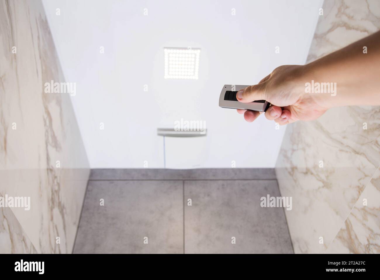 A man holds in his hand an exhaust ventilation control panel and a ...