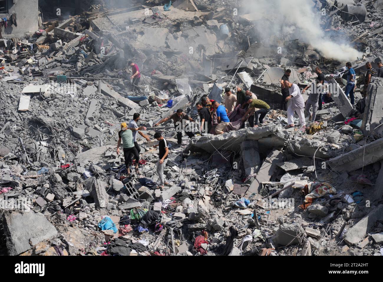 Palestinians pull dead from the building destroyed in an Israeli ...