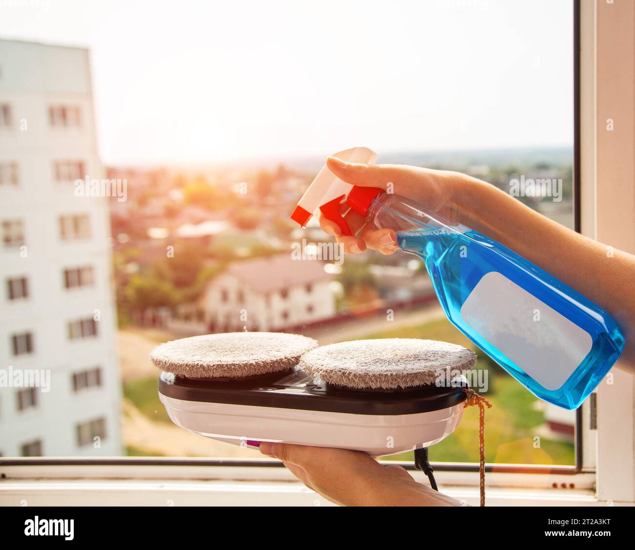 Spraying cleaning agent on the microfibers of a window cleaner robot ...