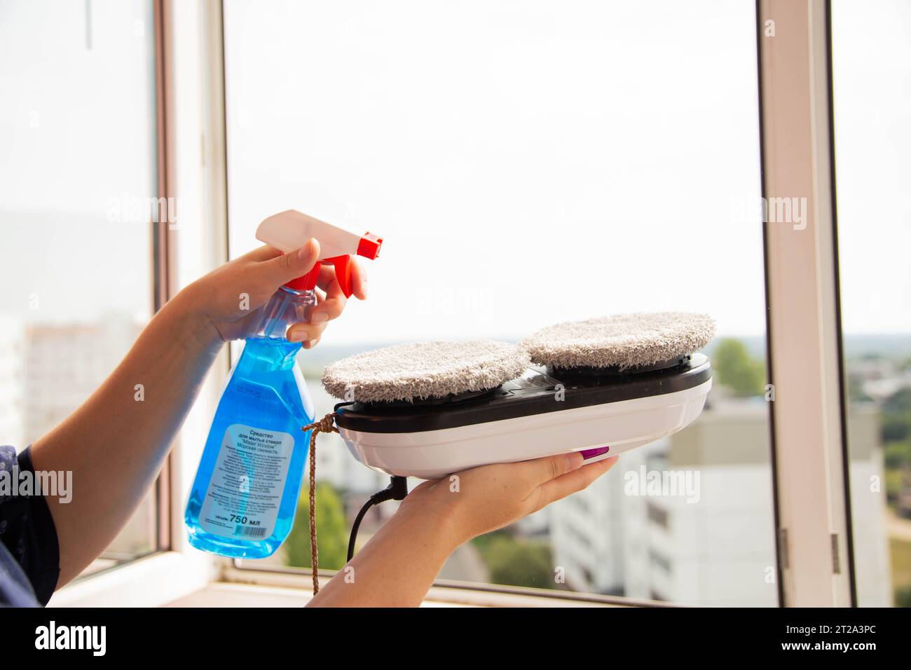 Spraying cleaning agent on the microfibers of a window cleaner robot ...