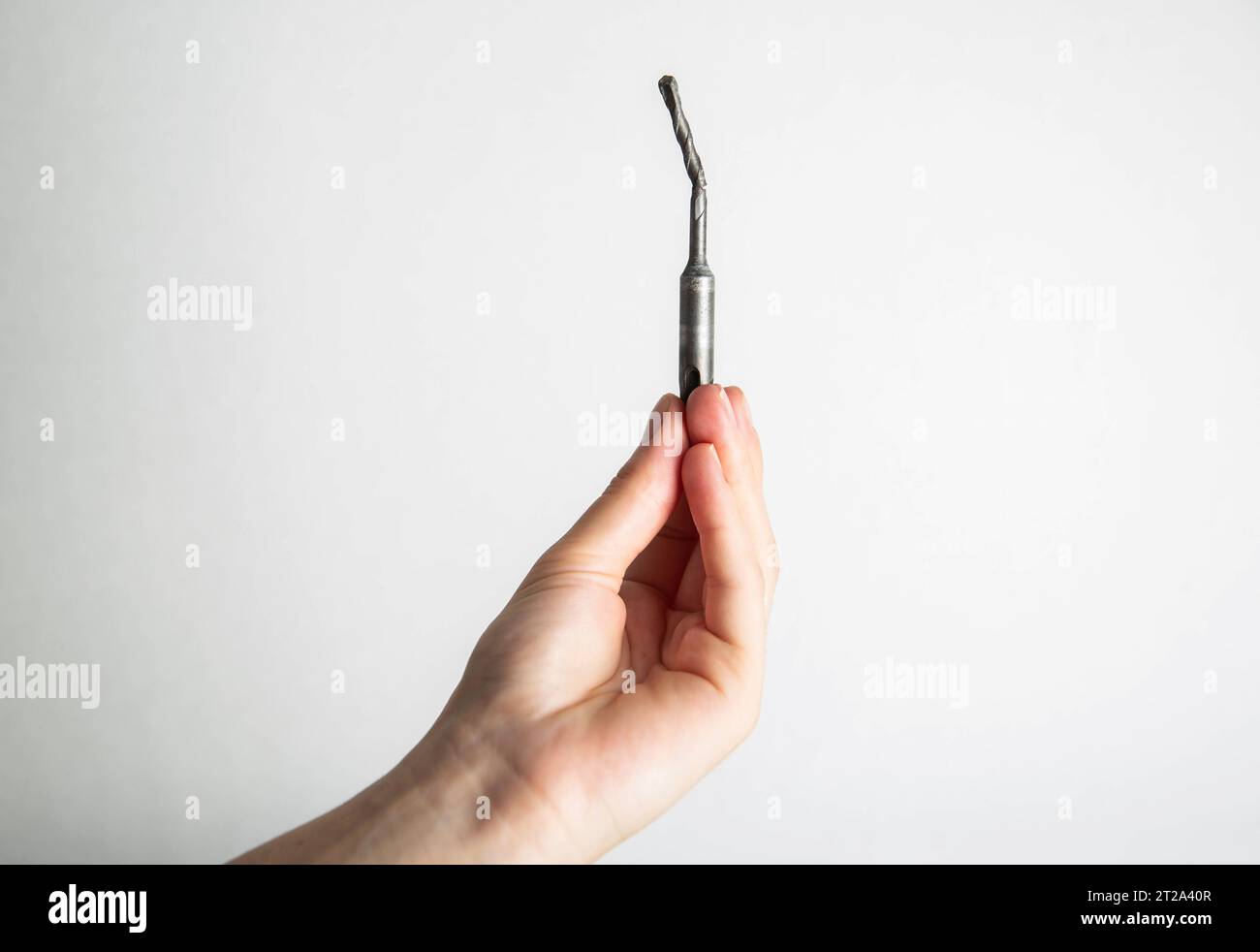 Poor quality broken metal drill on a white background Stock Photo - Alamy