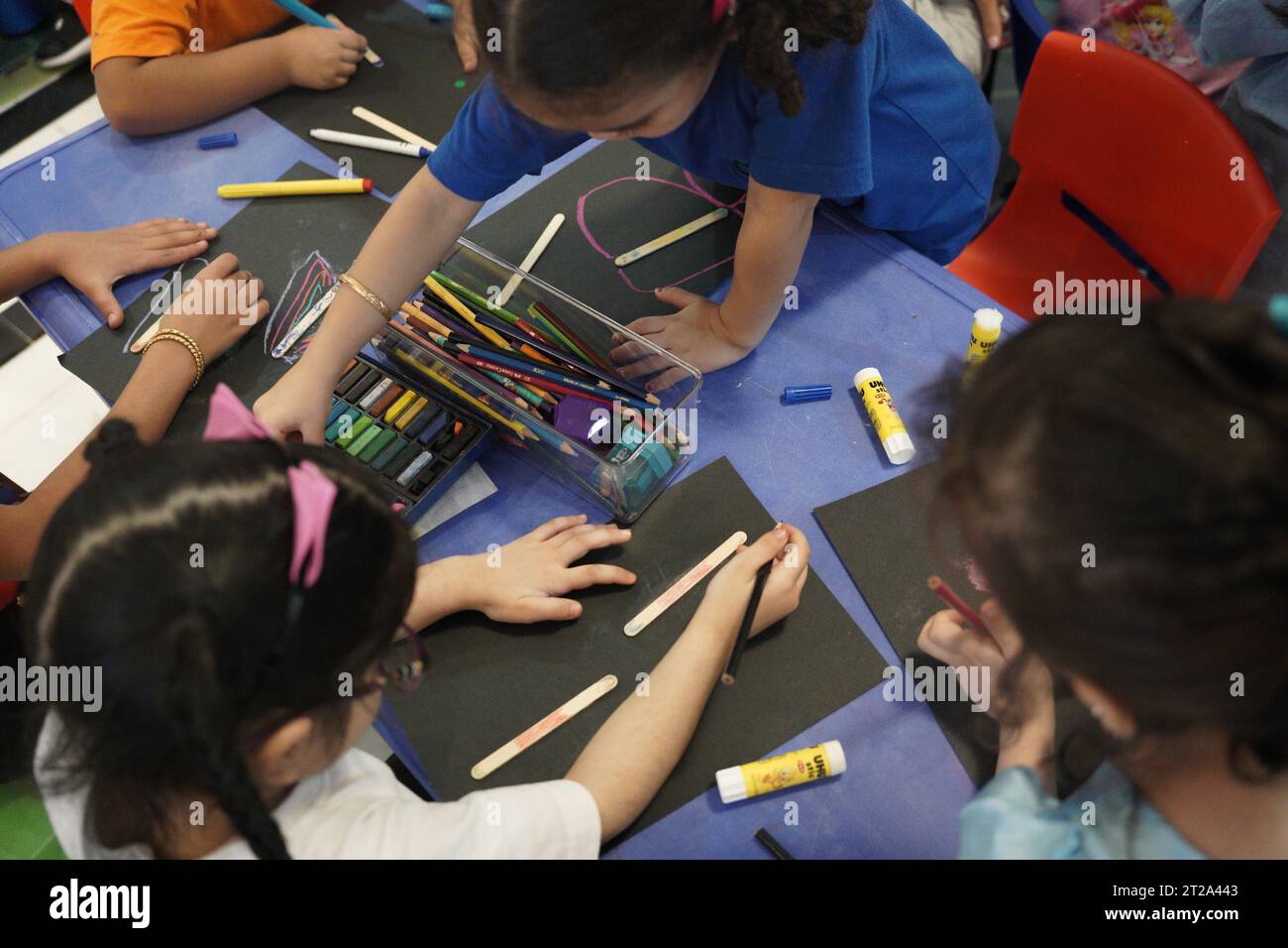 Kids chalk drawing. Kids colouring on black paper using chalk technique ...