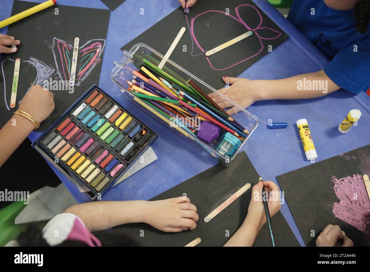 Kids chalk drawing. Kids colouring on black paper using chalk technique ...