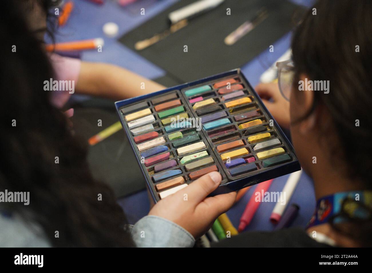 Kids chalk drawing. Kids colouring on black paper using chalk technique ...