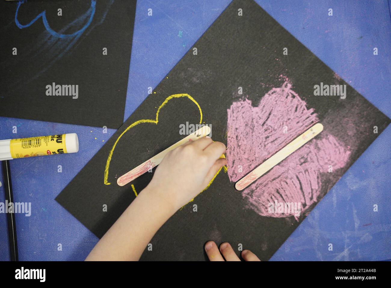 Kids chalk drawing. Kids colouring on black paper using chalk technique ...