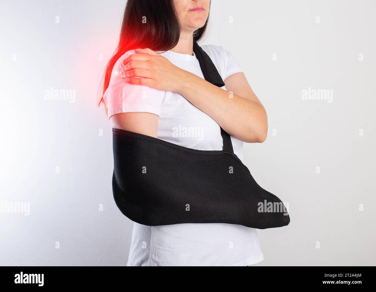 A girl on a white background with a black supporting medical bandage ...