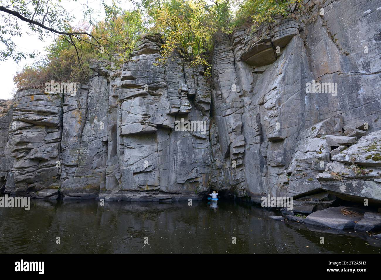 Canoe with people aboard going inside of a cave of rocks, excursion ...