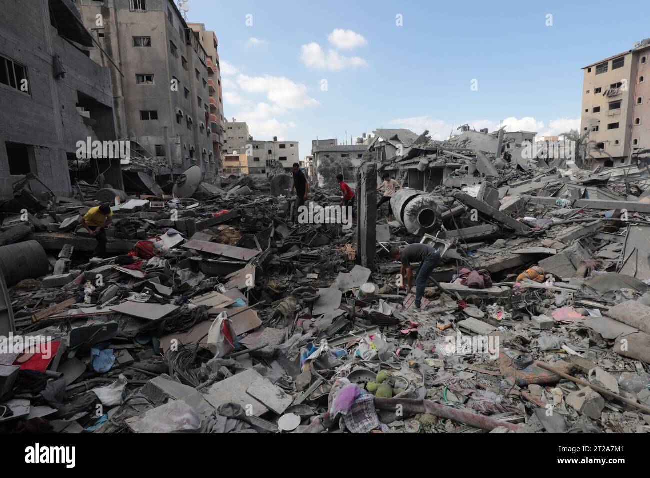 Palestinians inspect a destroyed buildings following the Israeli ...