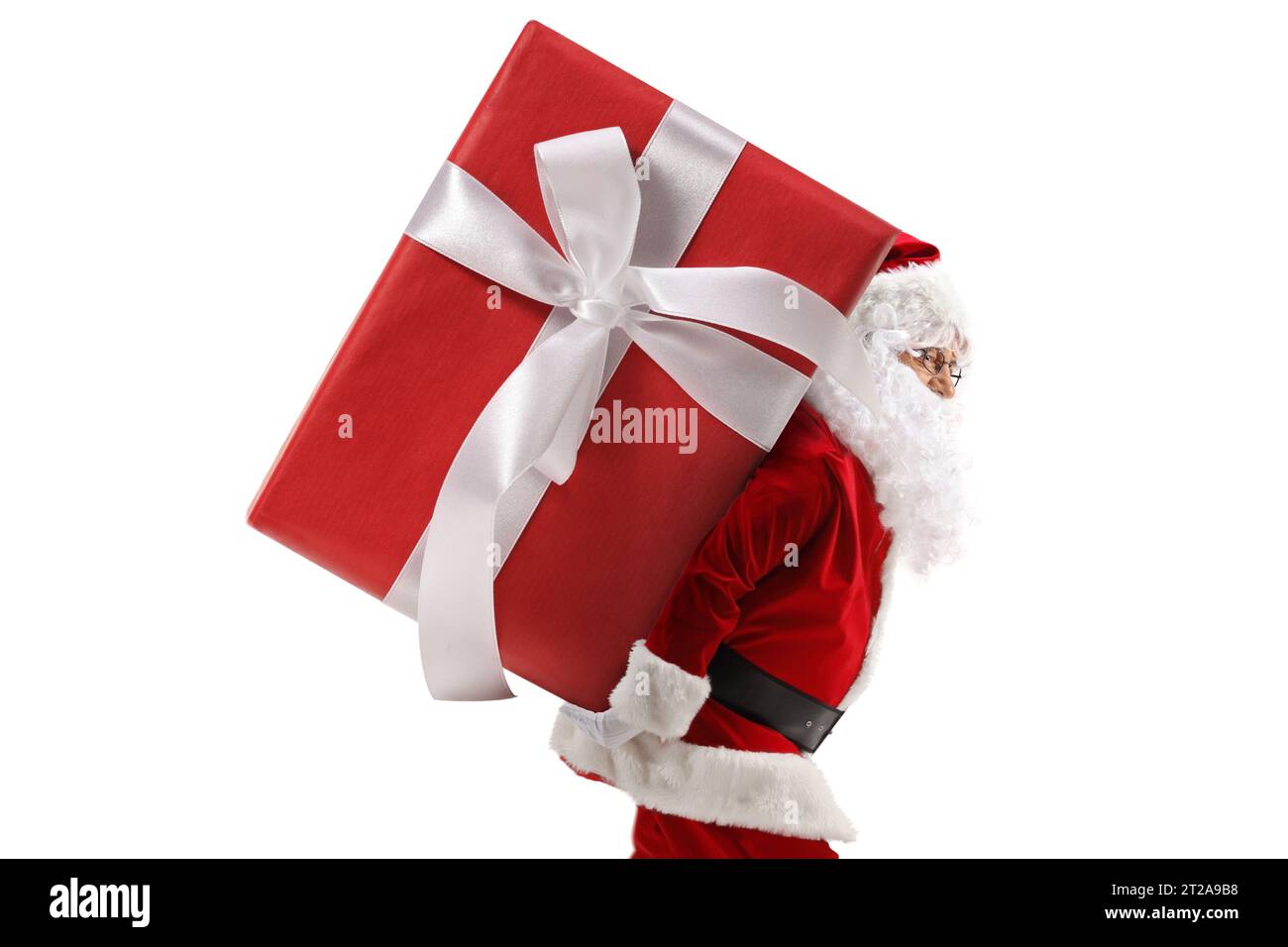 Profile shot of santa claus carrying a big preset on his back isolated ...