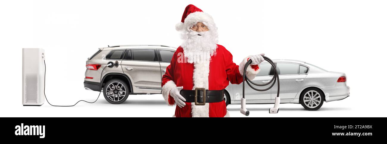 Santa claus with electric cars holding charger at ev charging point ...