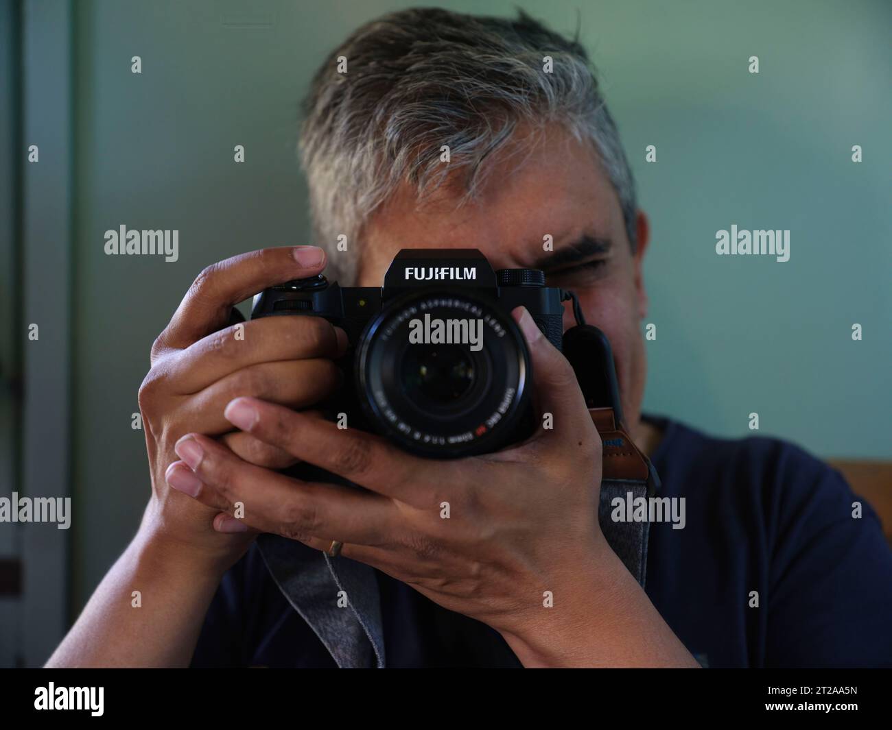 Man taking photos with his Fujifilm mirrorless camera Stock Photo - Alamy