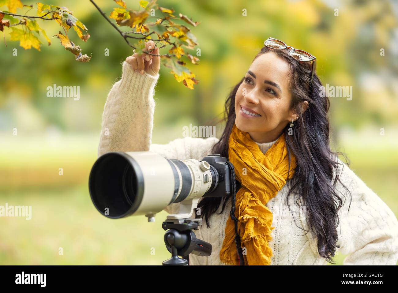 A professional female photographer stands next to her camera, taking ...