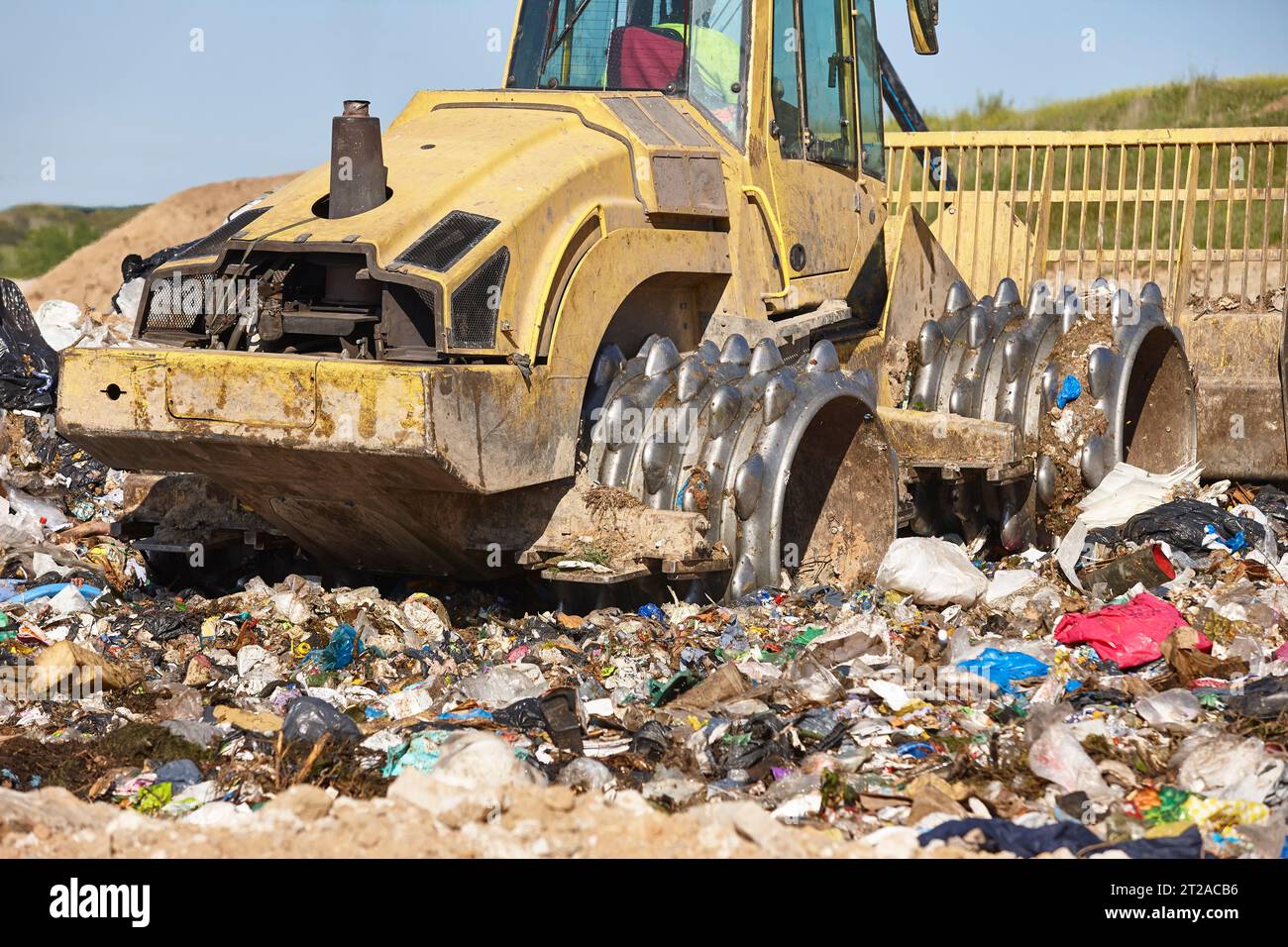 Heavy machinery shredding garbage in an open air landfill. Waste Stock ...