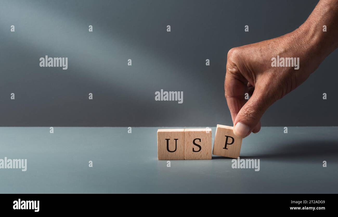 hand posing wooden blocks with the letters usp ,concept of unique ...
