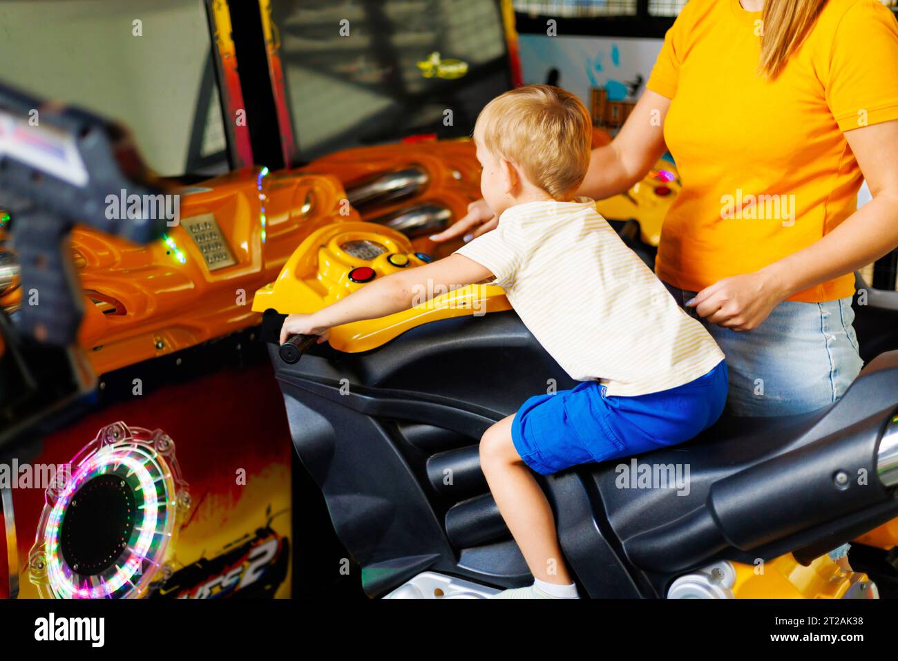 Kid playing arcade simulator machine at an amusement park Stock Photo ...