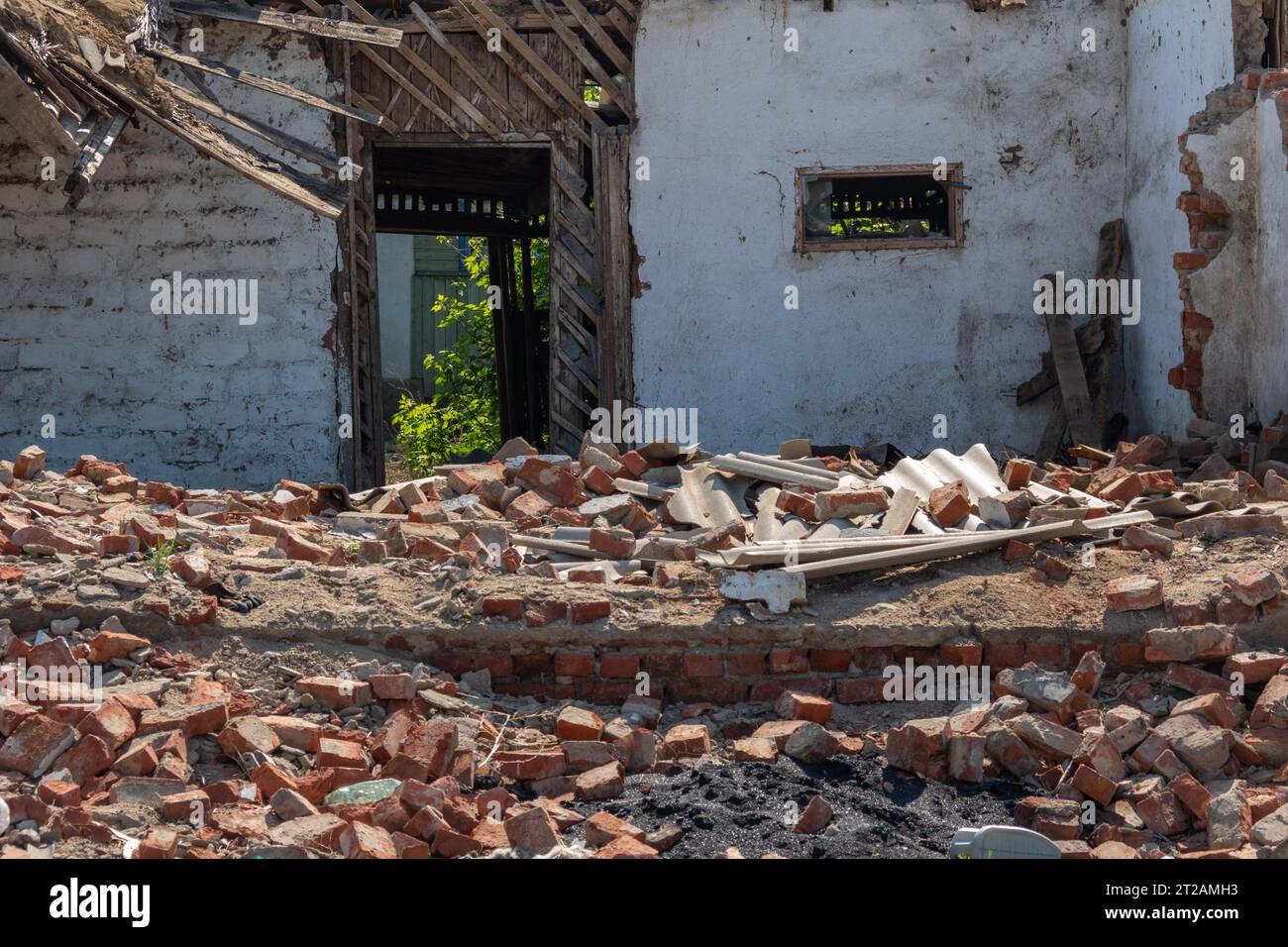 The white walls of an old ruined wooden village house. Broken walls, a ...