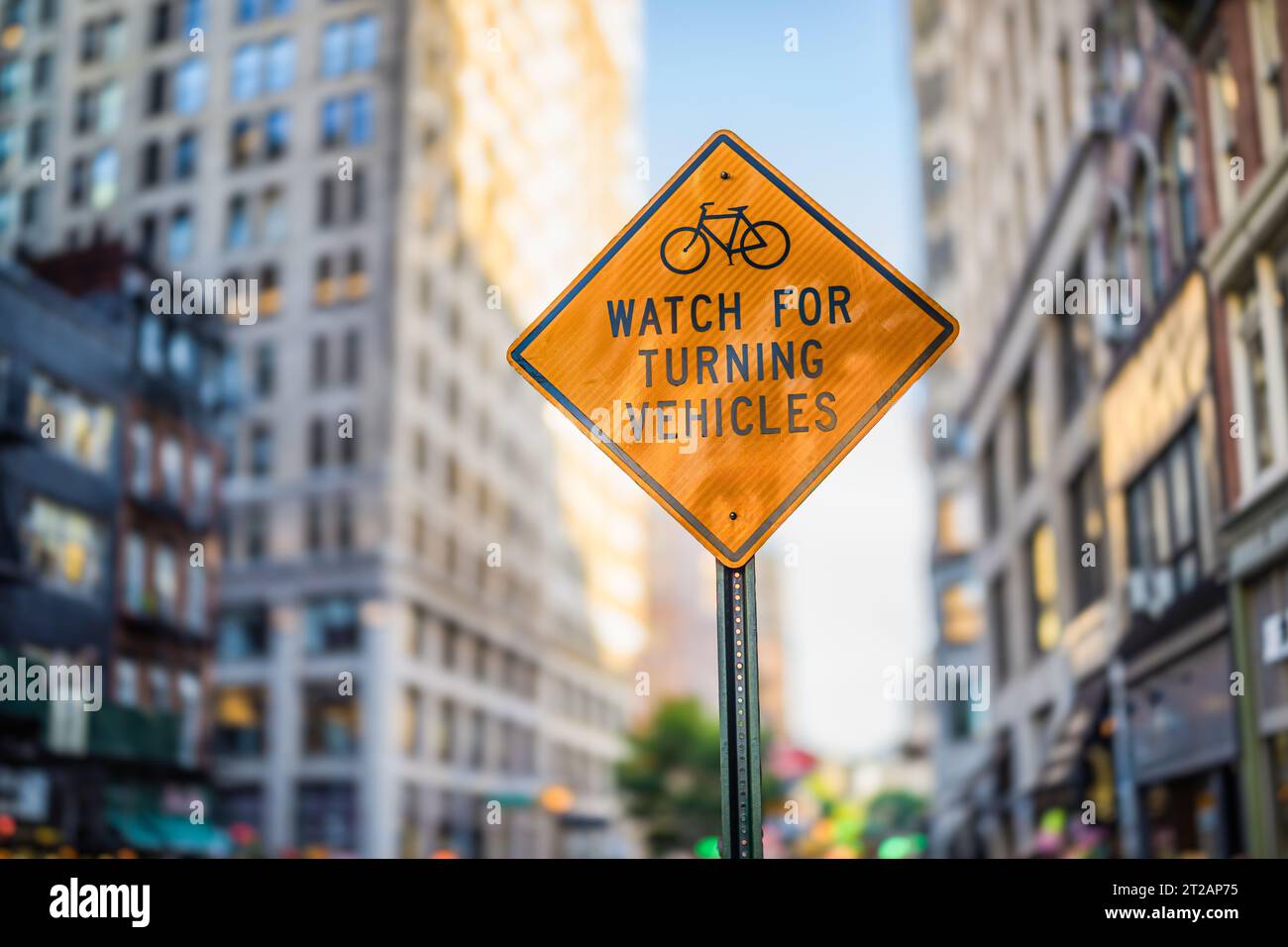 A warning sign for cyclists, '"watch for turning vehicles", on a street ...
