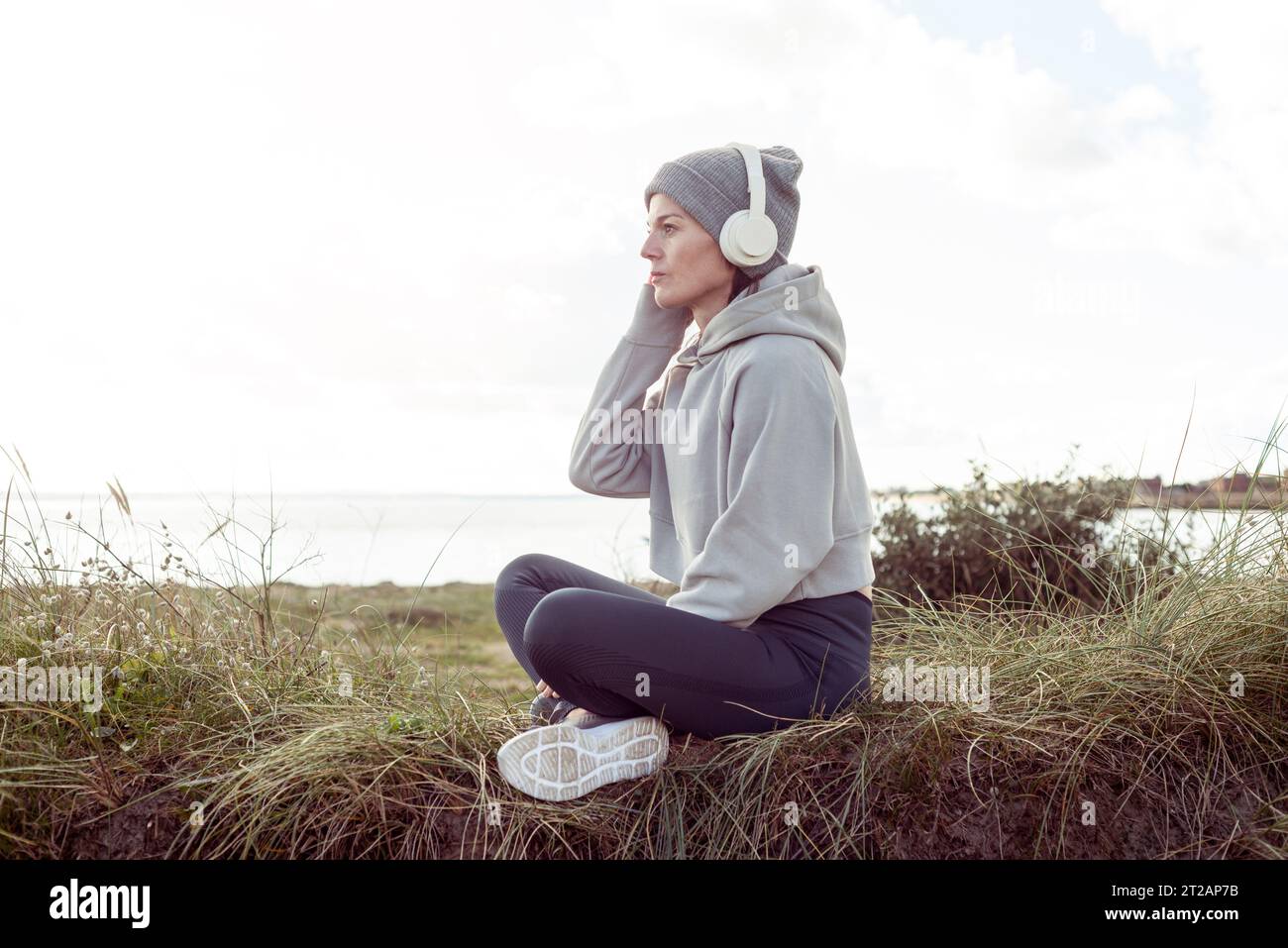 Sporty woman resting after exercise wearing headphones, outside Stock ...