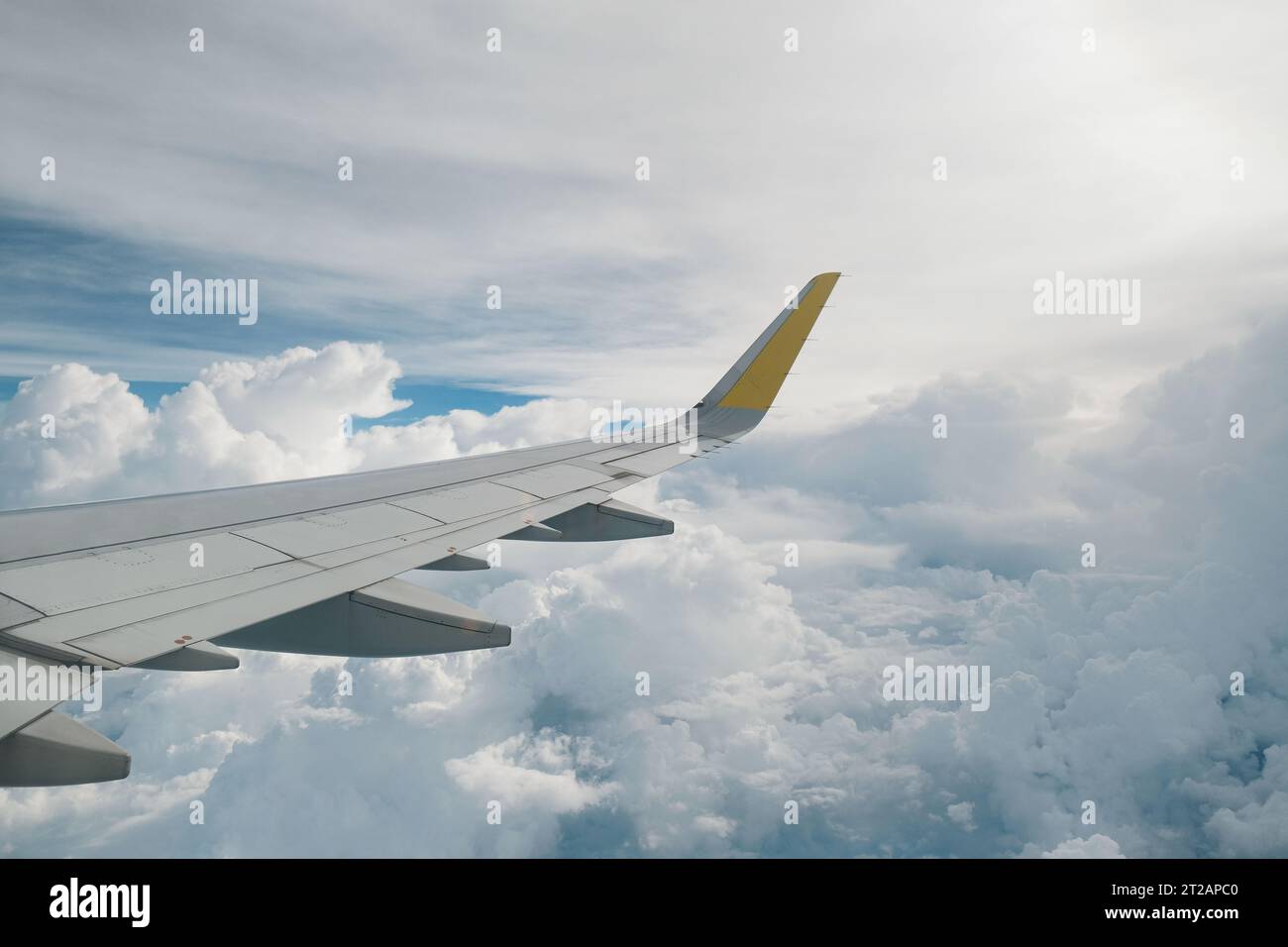 View of right wing from window of airplane flying up in the air. Clouds ...