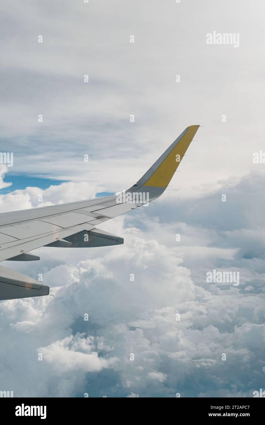 View of right wing from window of airplane flying up in the air. Clouds ...